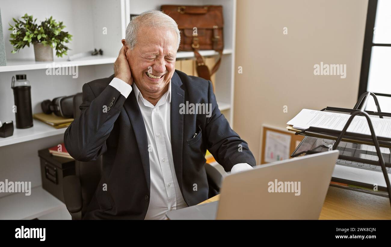 Stressed senior man suffering from cervical pain while working ...