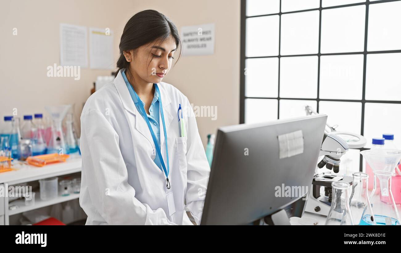 South asian woman scientist focusing on computer screen in laboratory ...