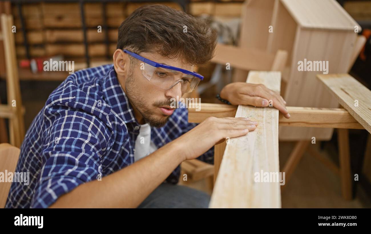 Hard-at-work, handsome young arab carpenter focused on woodworking job ...