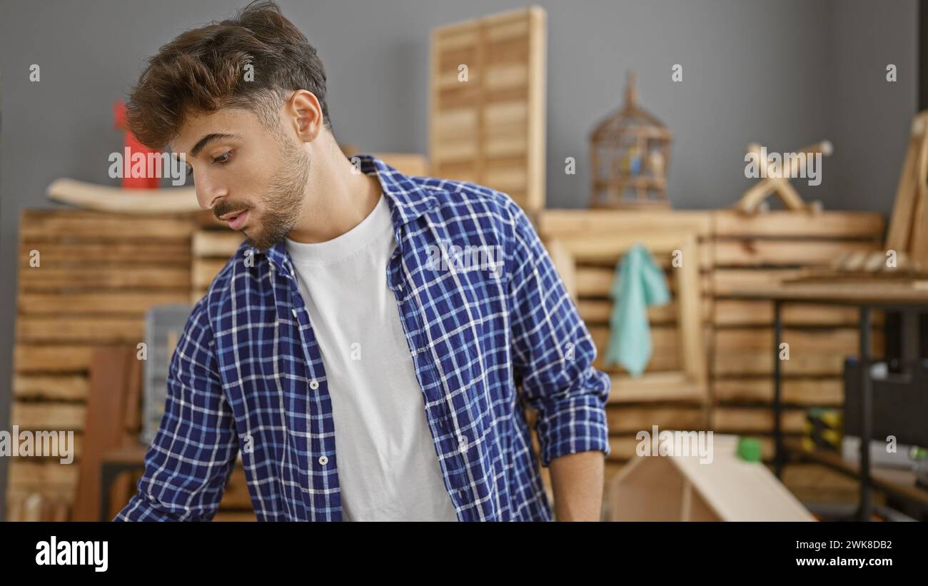 Handsome, serious-faced young arab man, a master carpenter, standing ...