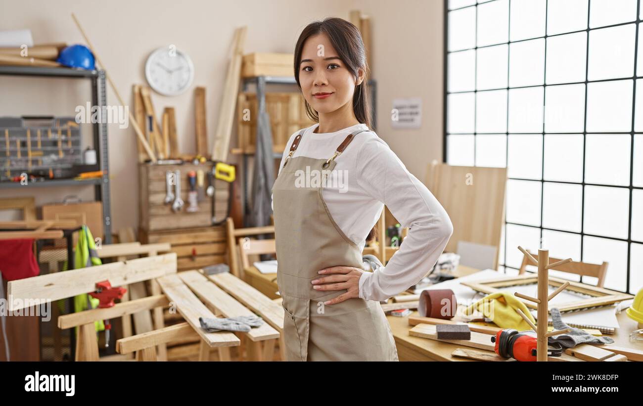 A confident young asian woman posing in a well-equipped carpentry ...