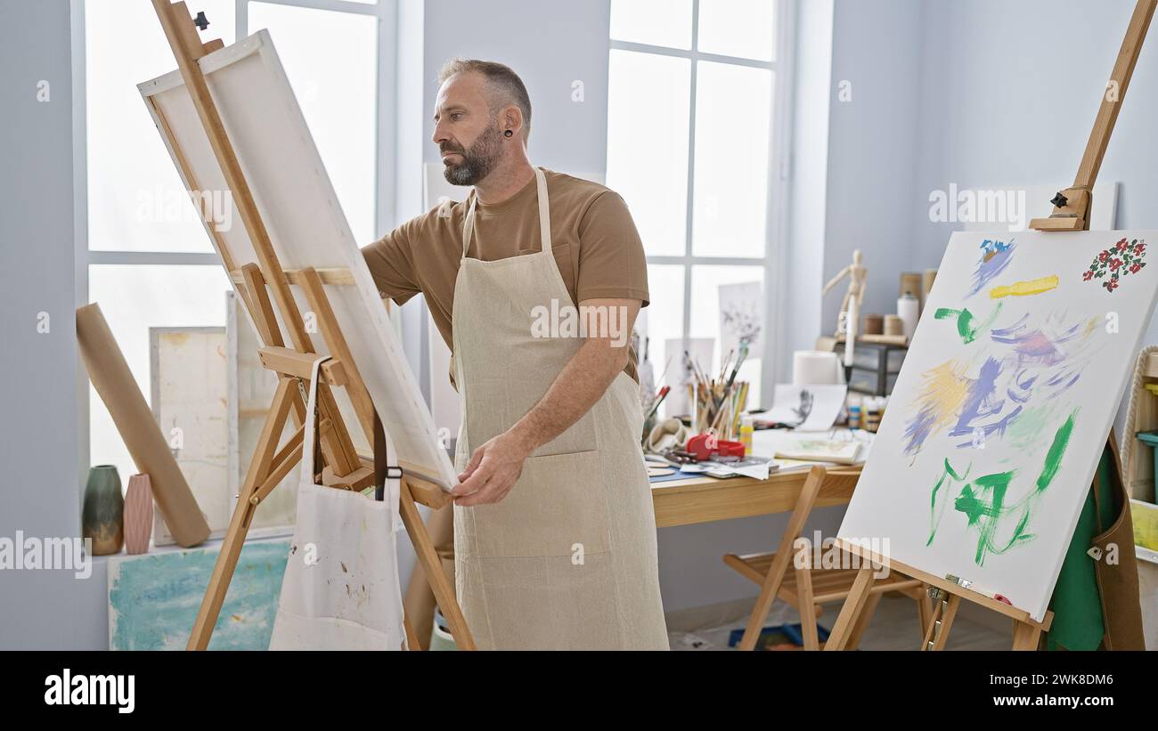 Handsome young man artist intensely drawing at his relaxed art studio ...
