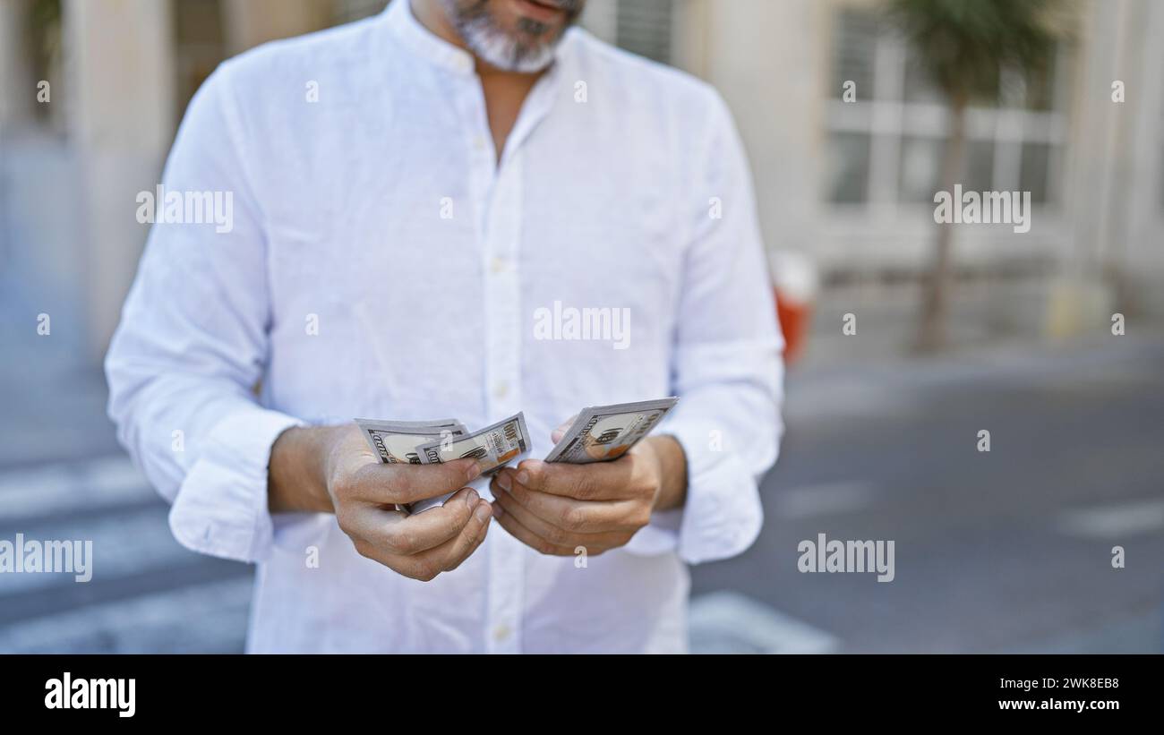 Handsome young hispanic man with grey hair, casually standing on a ...