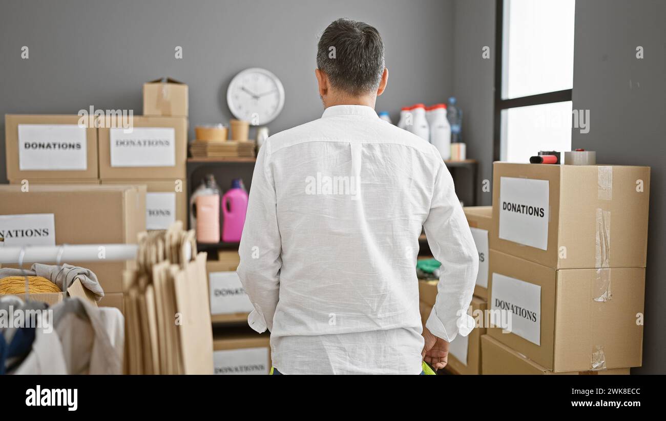 Selfless young hispanic man, a grey-haired volunteer, giving back by ...