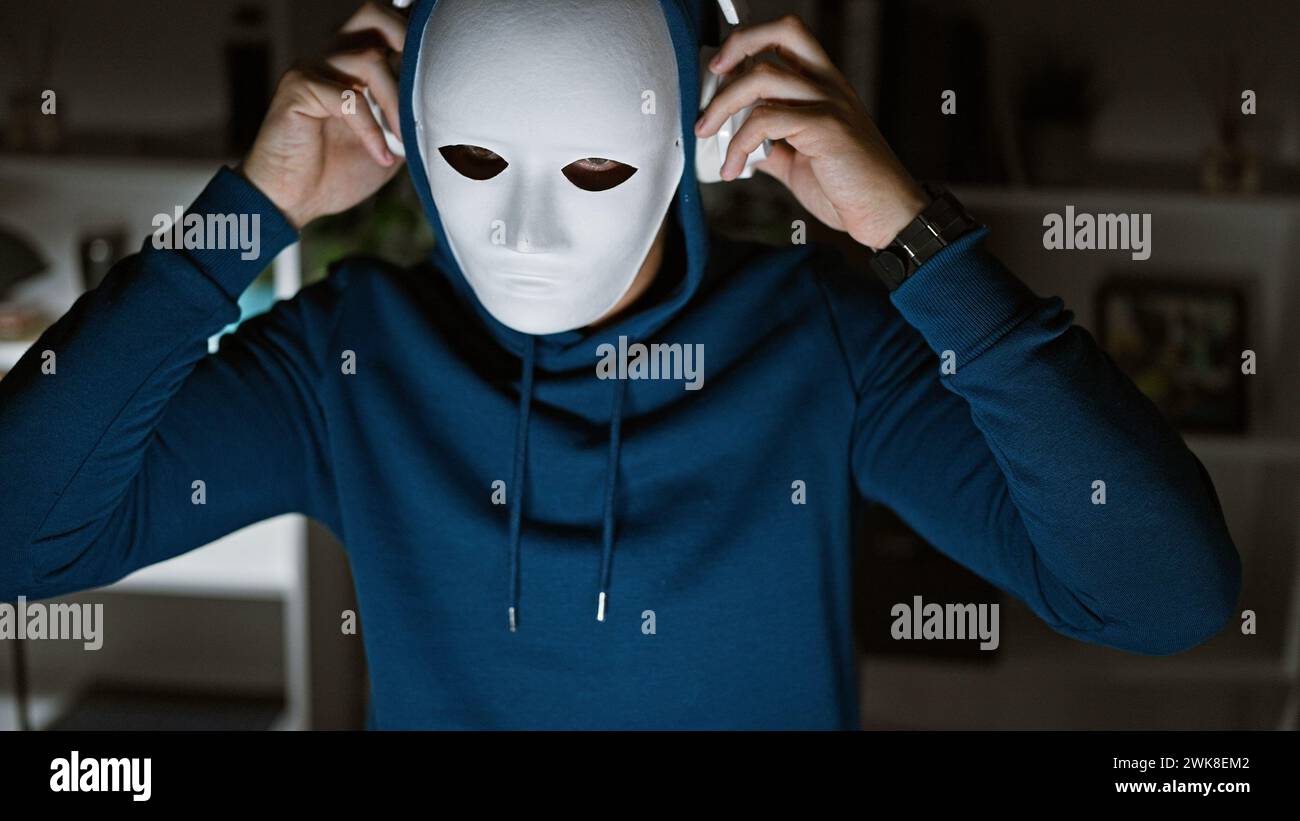 A mysterious man donning a plain mask in a casual indoor setting Stock ...