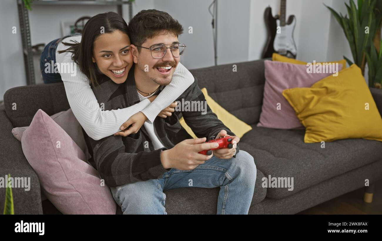 A cheerful couple enjoys gaming together in a cozy living room, evoking ...