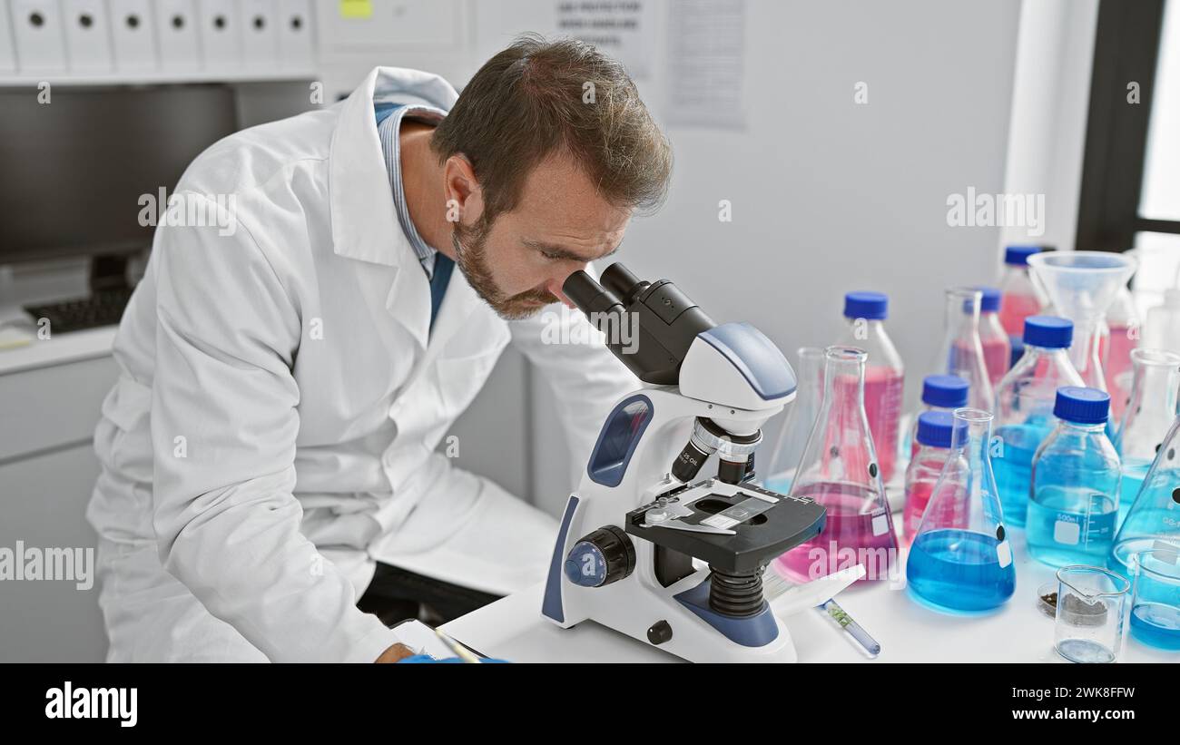 Hispanic scientist man analyzes samples using a microscope in a ...