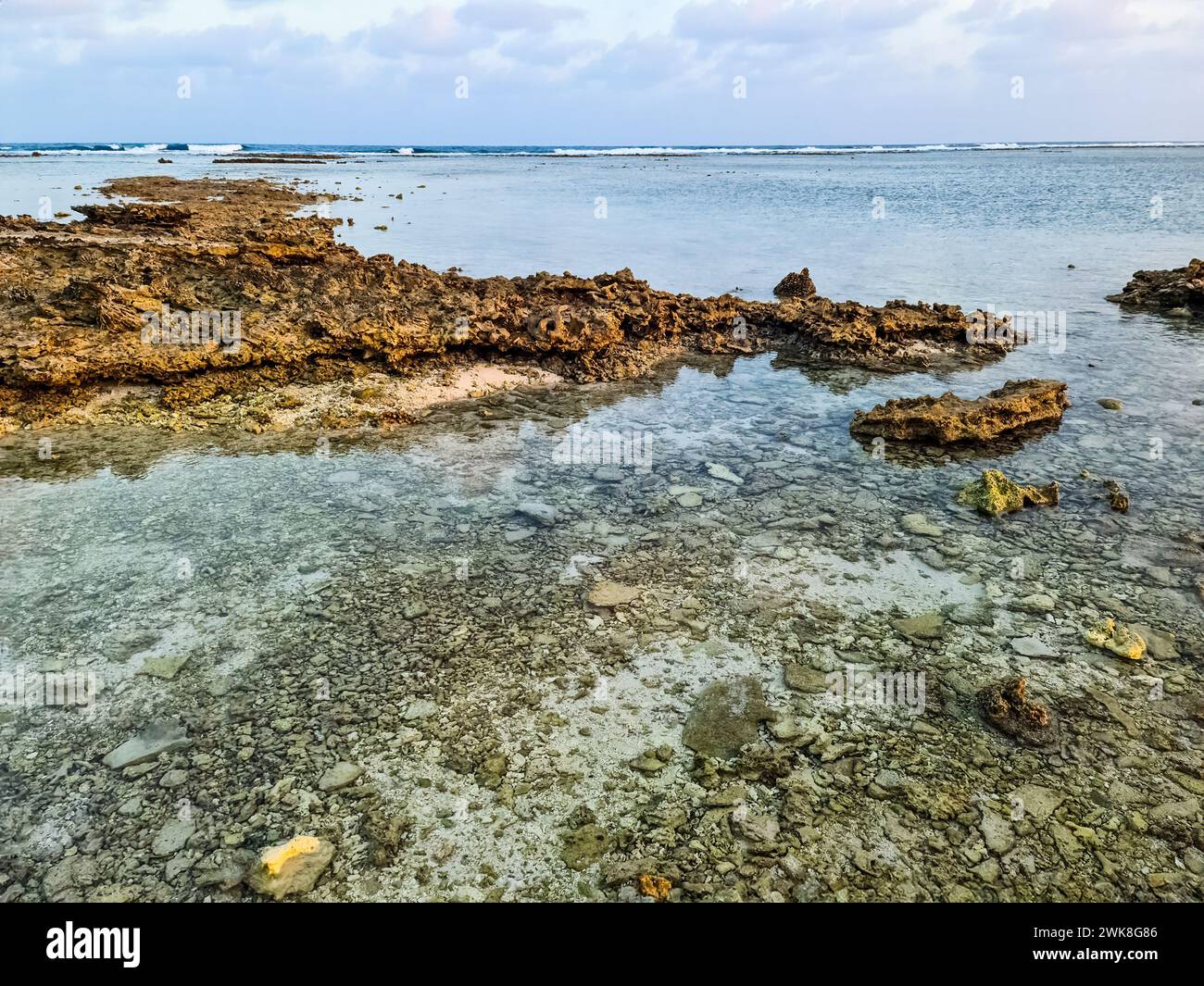 View of the Maldives beach with lots of rocks and pale coral Stock ...