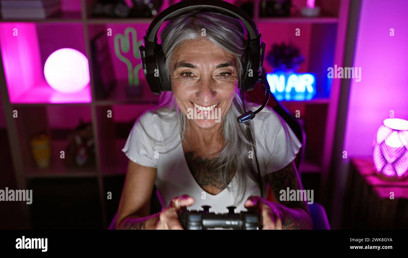 Smiling grey-haired, middle age woman streamer confidently playing ...