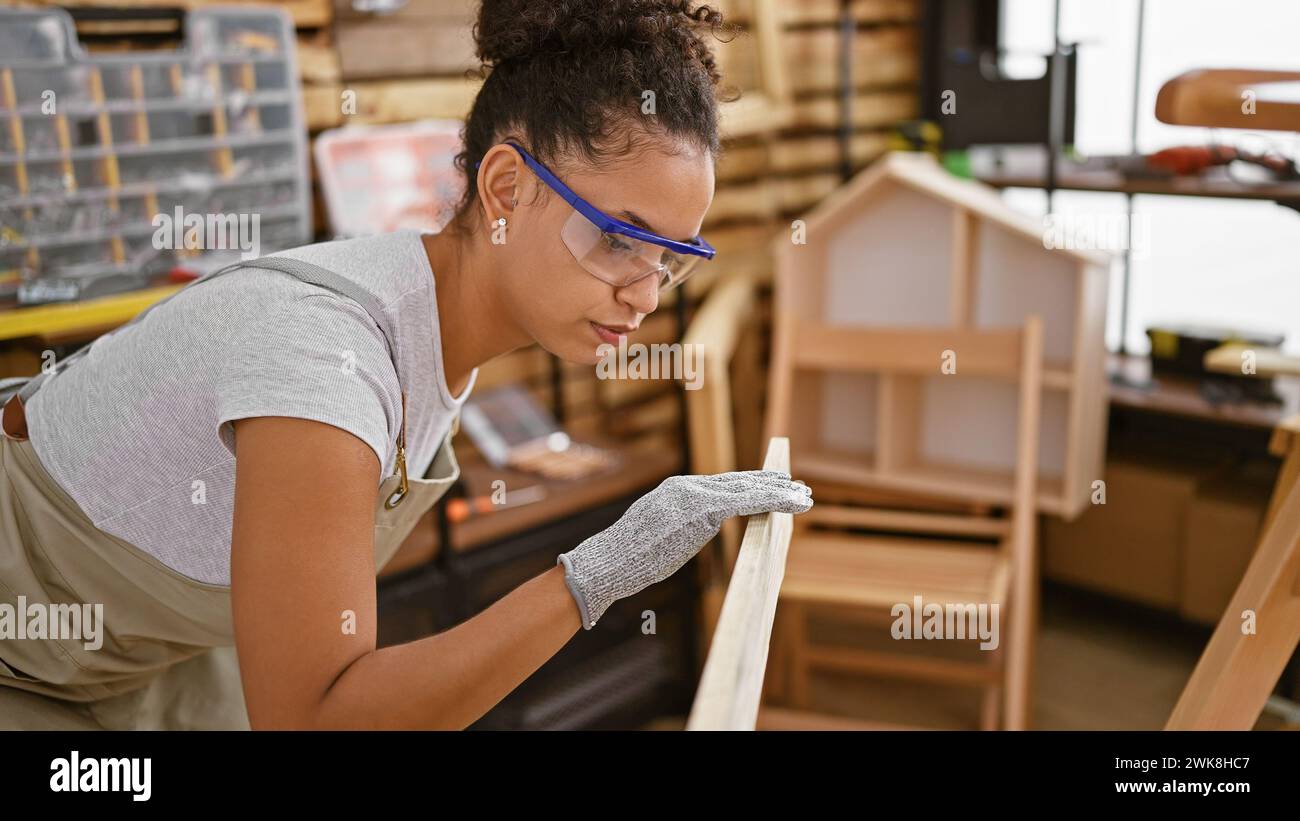 Beautiful young hispanic female carpenter gently touching a plank of ...