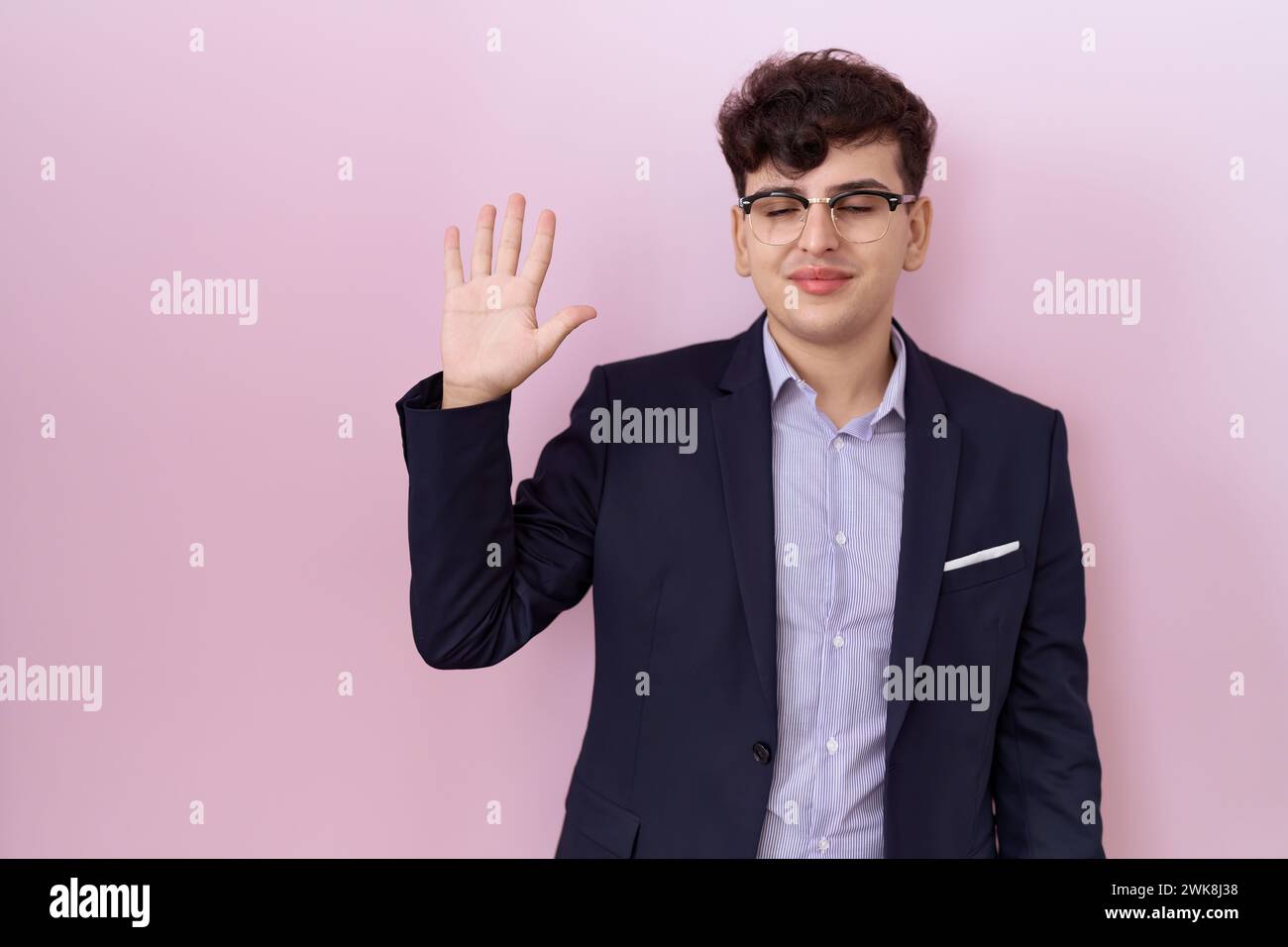 Young non binary man with beard wearing suit and tie showing and ...