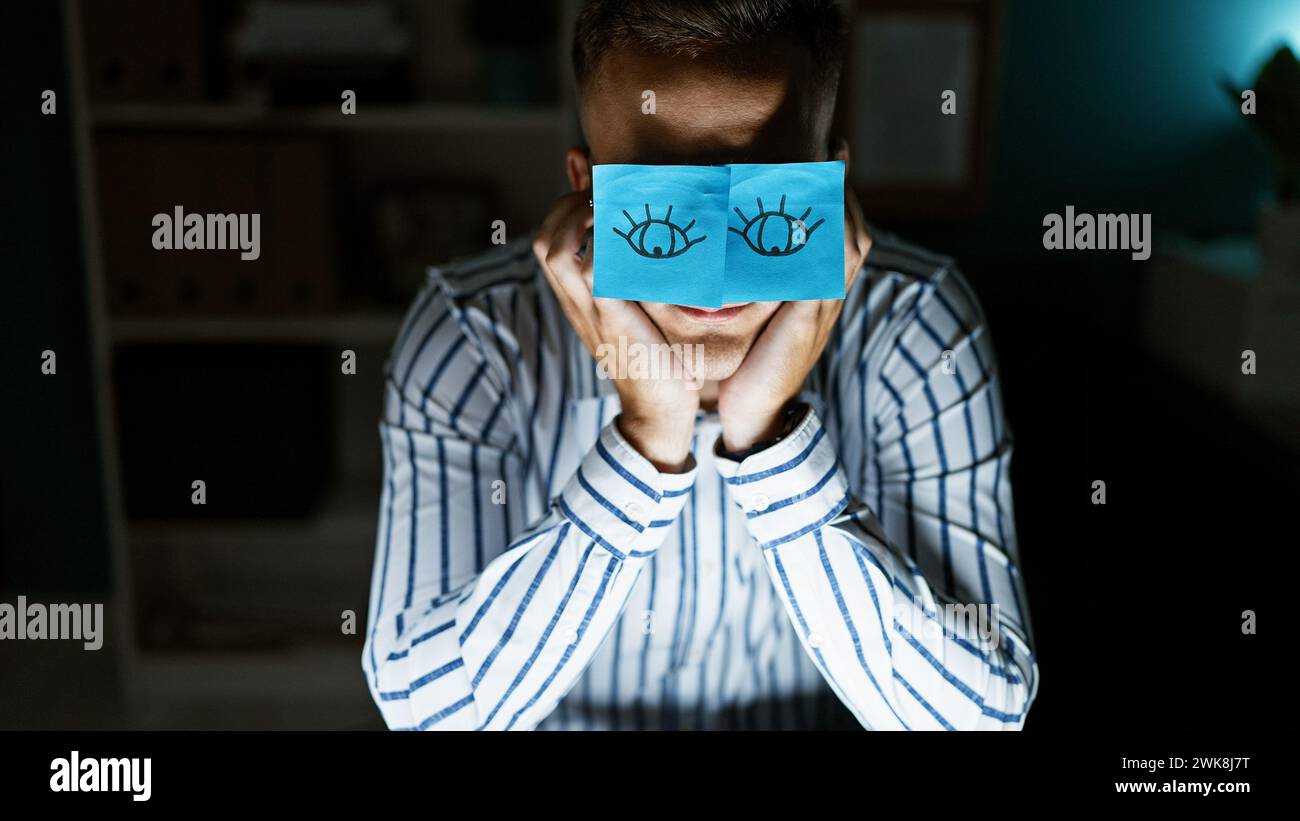 A humorous portrait of a young man in an office, holding a sticky note ...