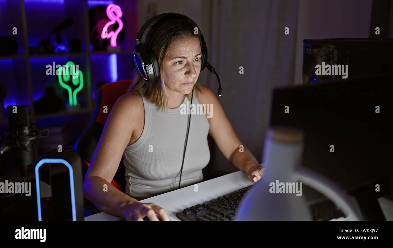 Attractive young blonde woman streamer, locked in her gaming room ...