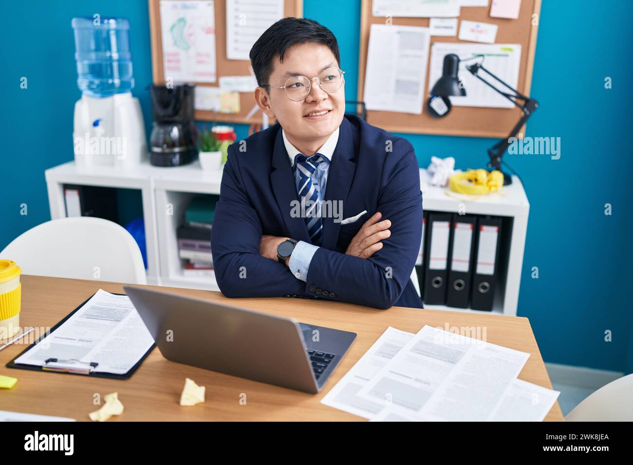 Young chinese man business worker smiling confident sitting with arms ...