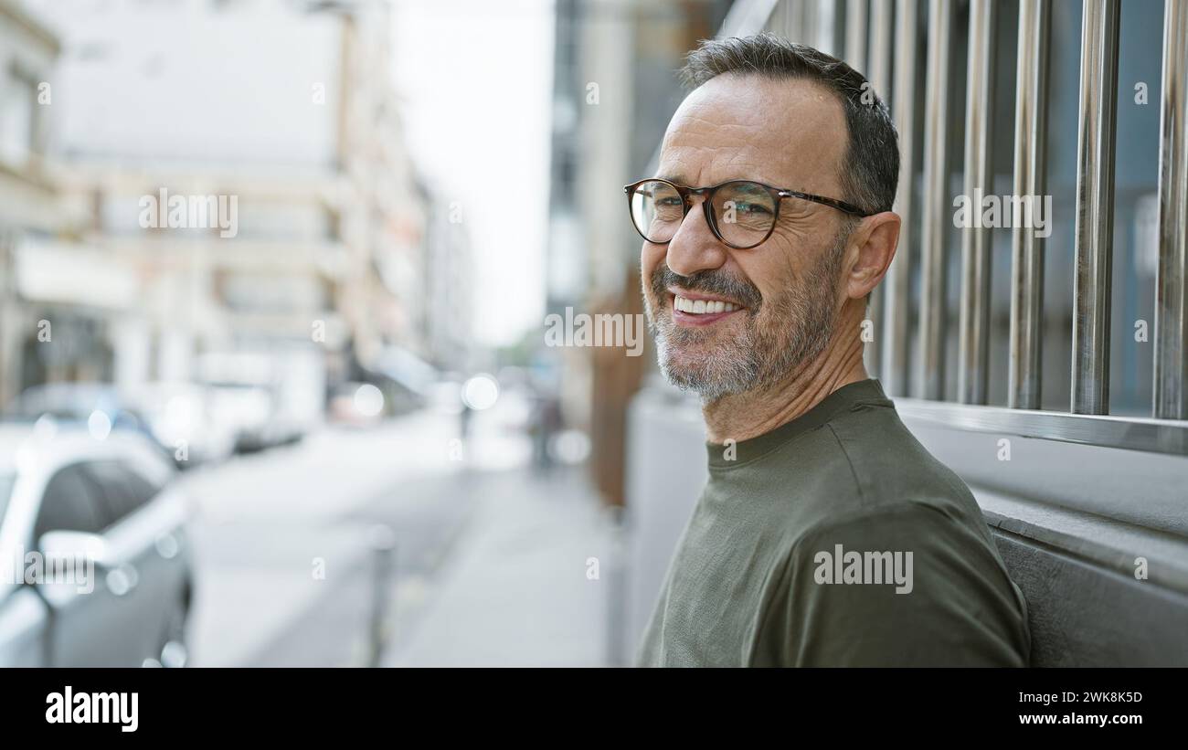 Brimming with joy, middle age man with grey hair stands confidently on ...