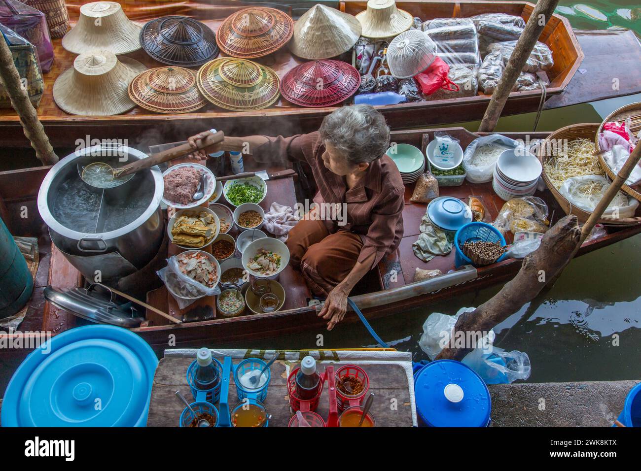 A Thai woman preparing food on her floating kitchen boat in the Damnoen ...