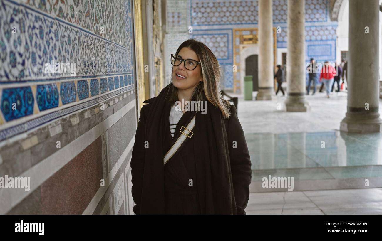 Smiling woman admires ornate tiles at topkapi palace in istanbul ...