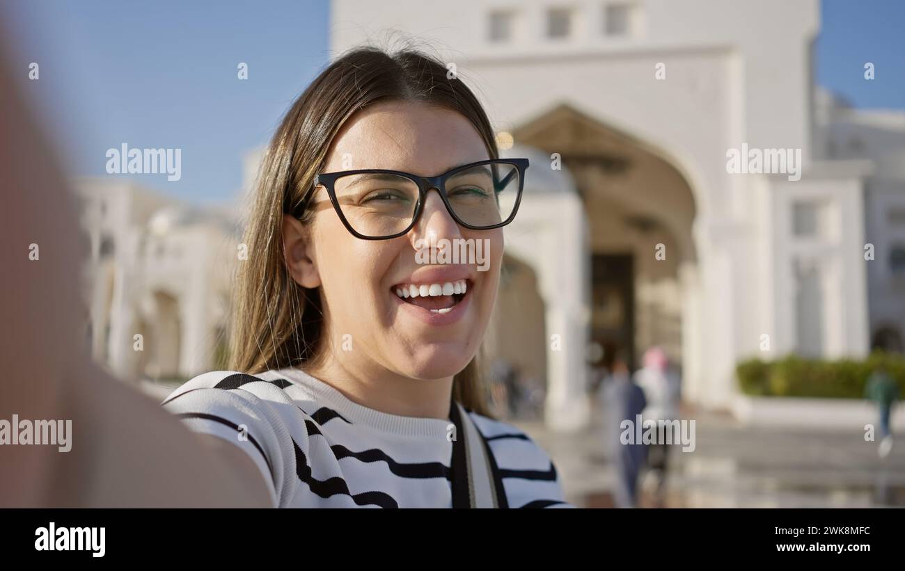 A smiling young woman enjoys tourism at qasr al watan palace in abu ...