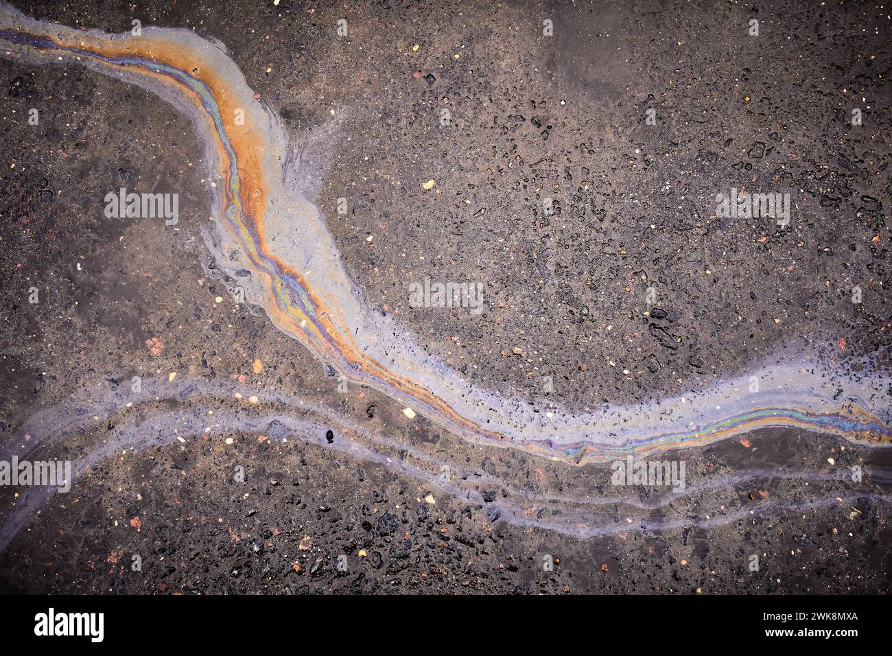 A colorful stain of engine oil on the road Stock Photo - Alamy