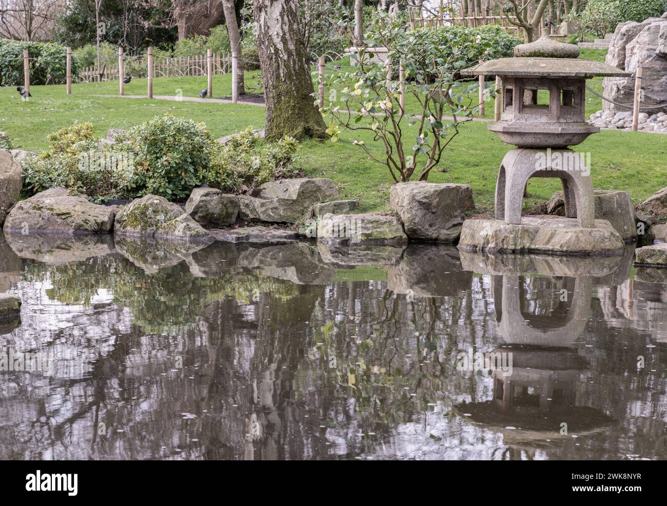 Decorative japanese stone lantern on Summer zen lake pond water. A ...
