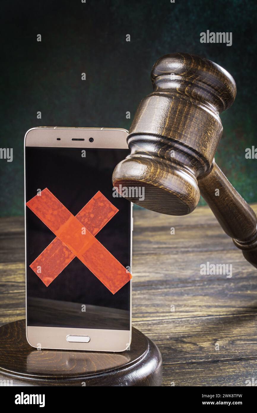 Judge gavel with a smartphone with a taped screen.Communications ban or ...