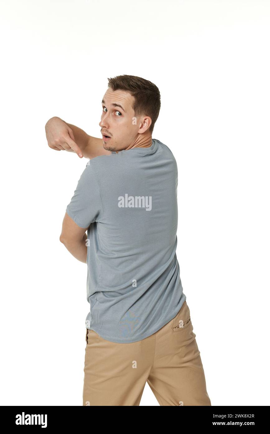 happy guy looking pointing to his back on white studio background Stock ...