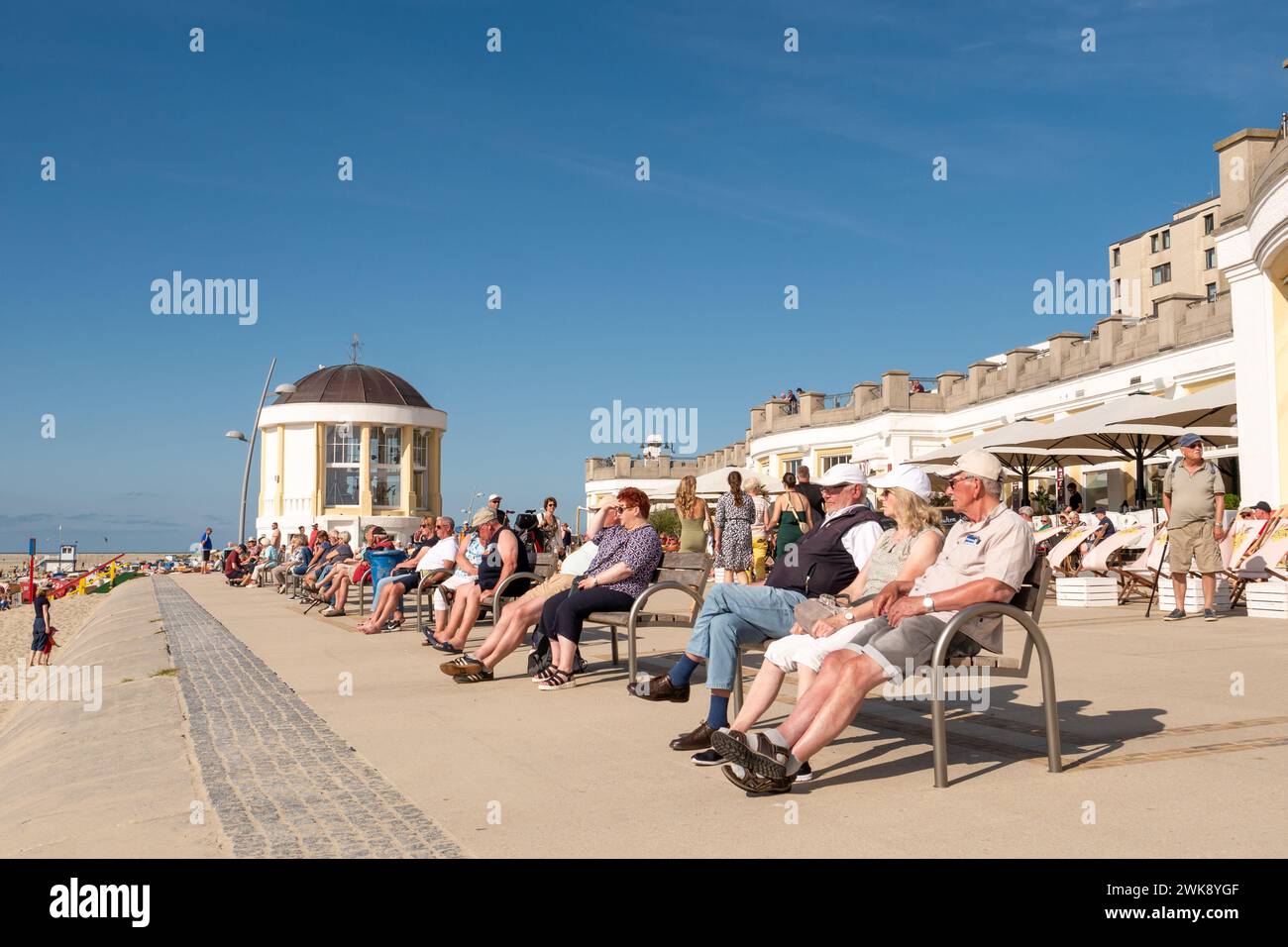 Senior people sitting on benches on beach promenade on Borkum island ...
