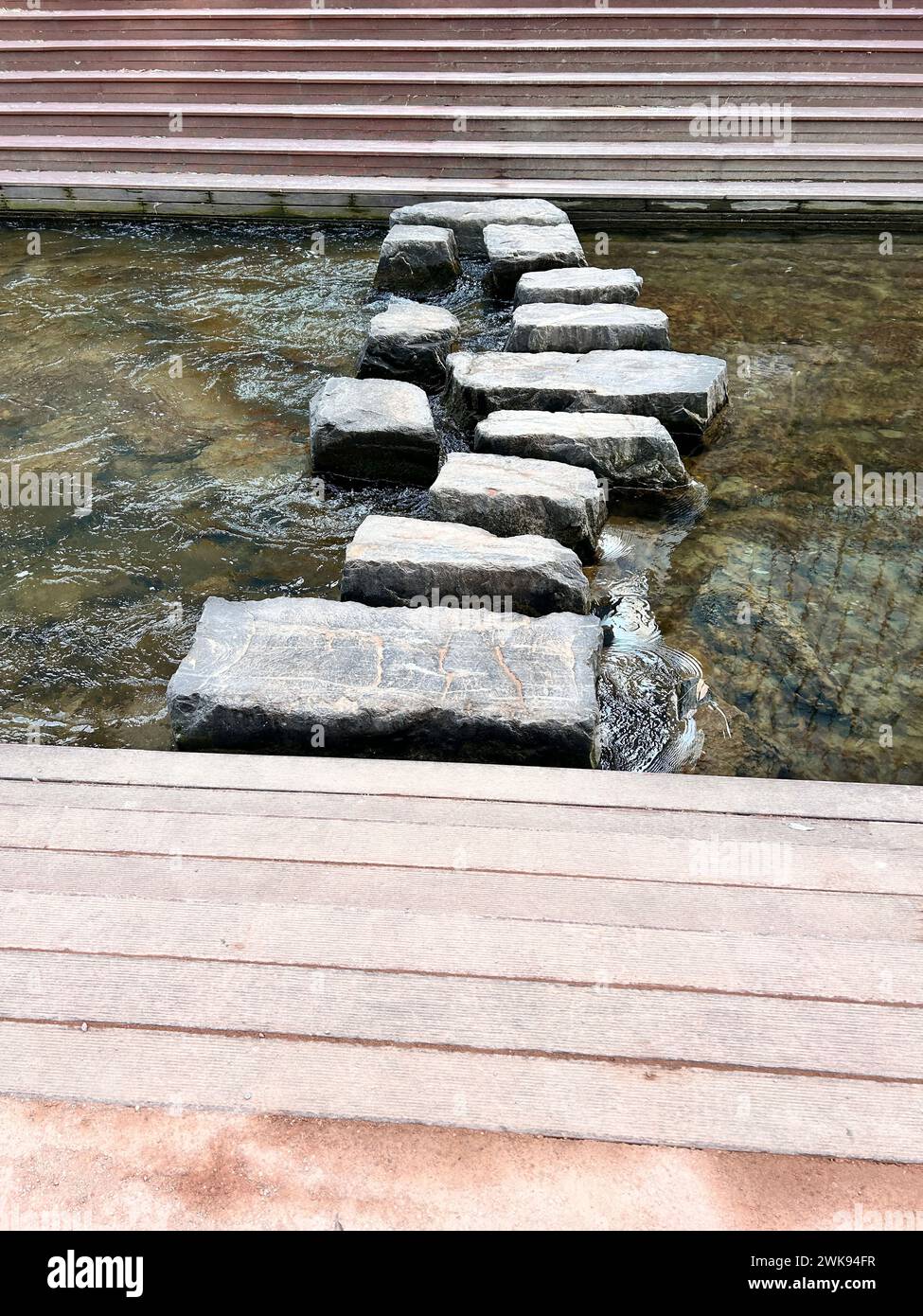 A wooden platform with stepping stones crossing a small river ...