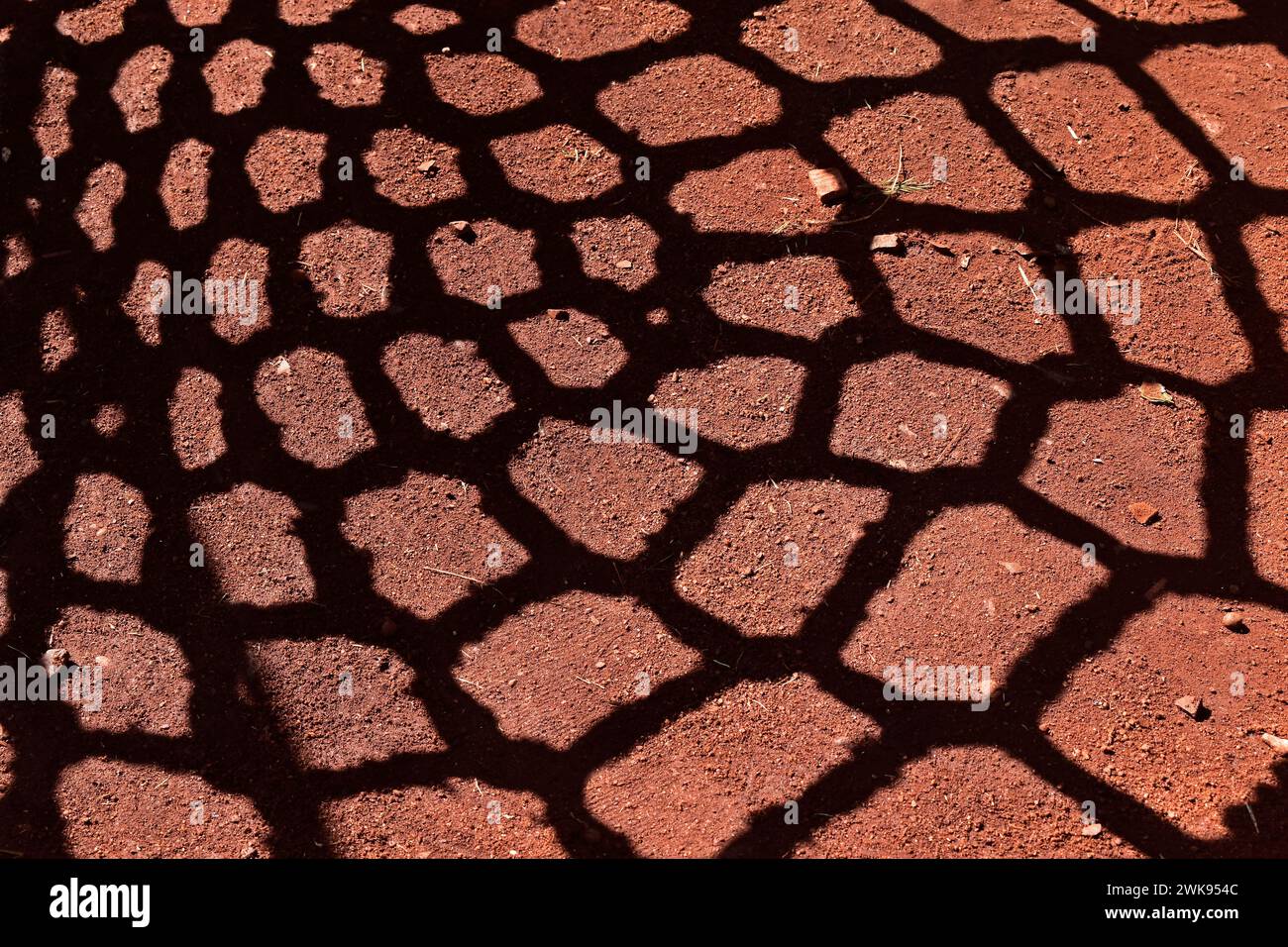 Rope net shadow detail on red soil in playground Stock Photo - Alamy