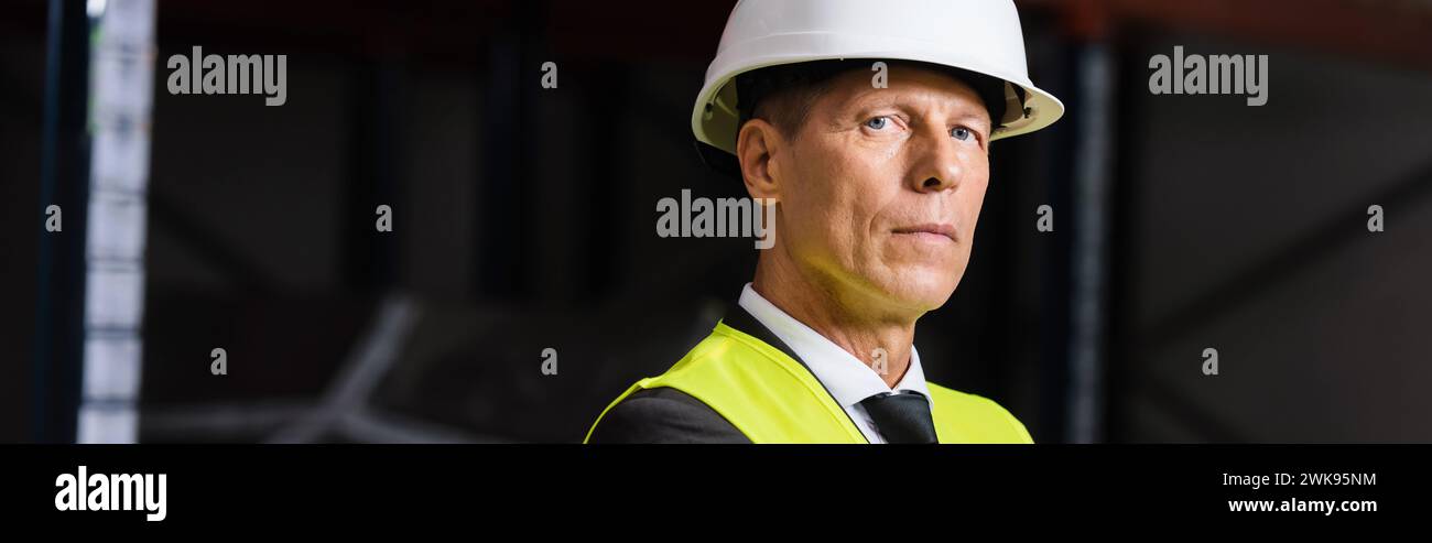 confident man in safety vest and hard hat looking at camera in ...