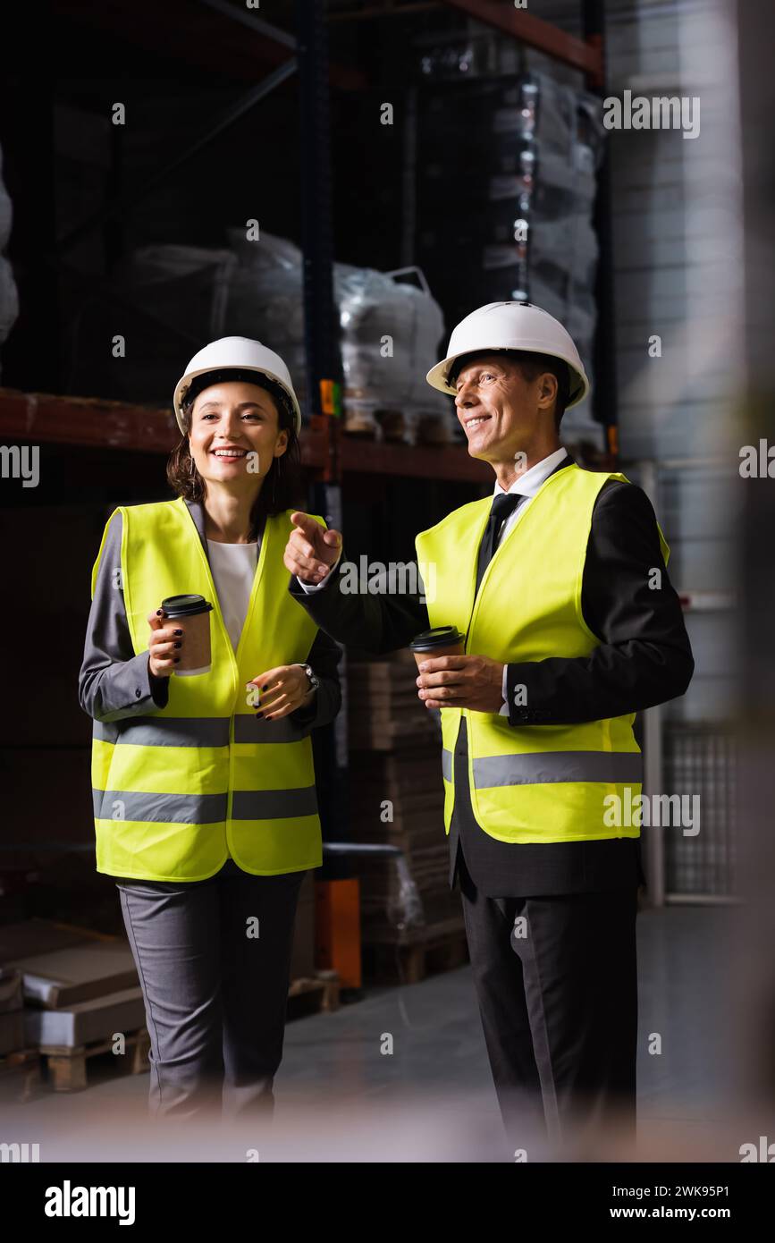 logistics team, happy supervisor in hard hat and coffee showing ...