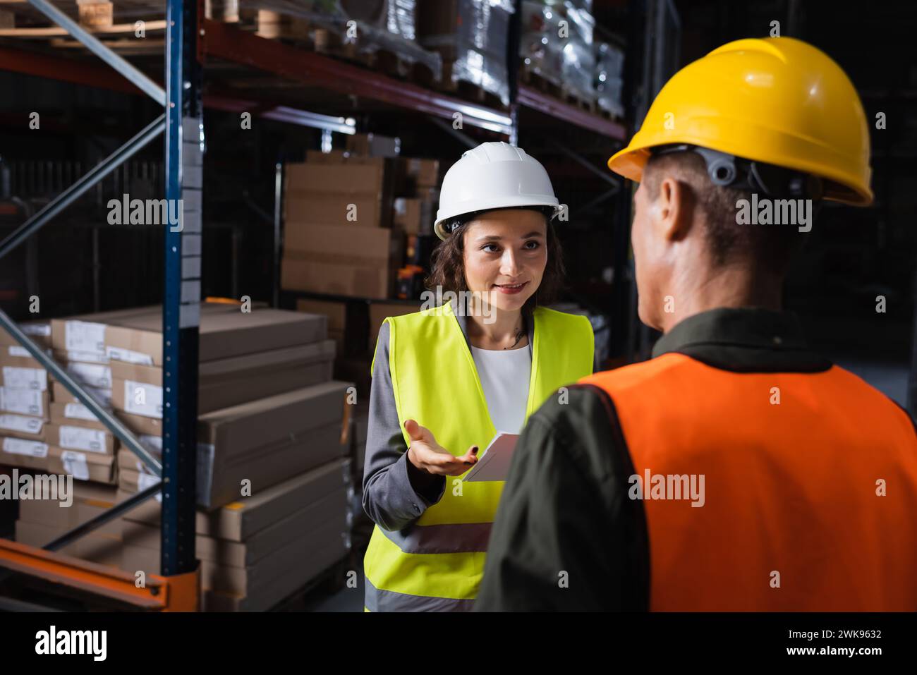 warehouse workers discussing logistics, cheerful woman with folder ...