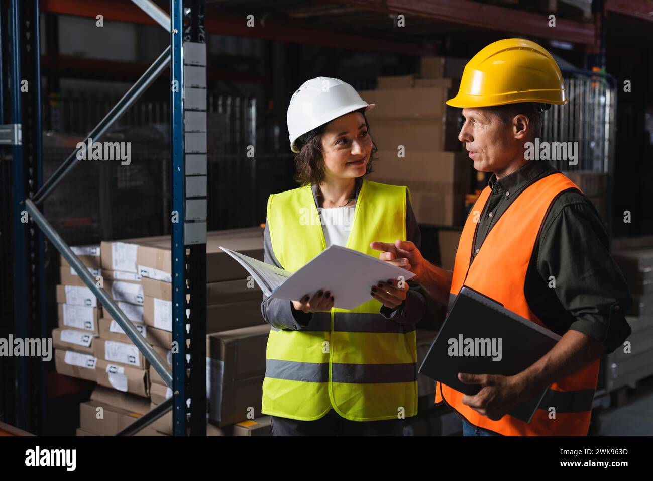 Two warehouse workers discussing logistics, happy middle aged man ...