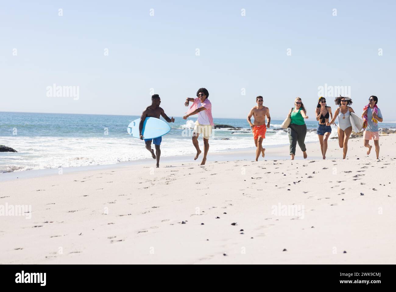 Diverse group of friends enjoy a day at the beach with copy space Stock ...
