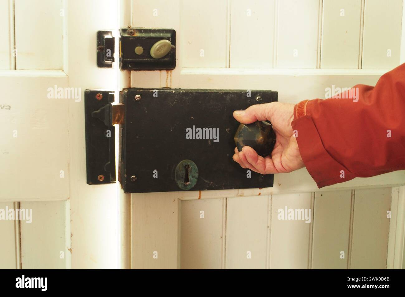 A man's hand opening a heavy church door from the inside, showing the ...