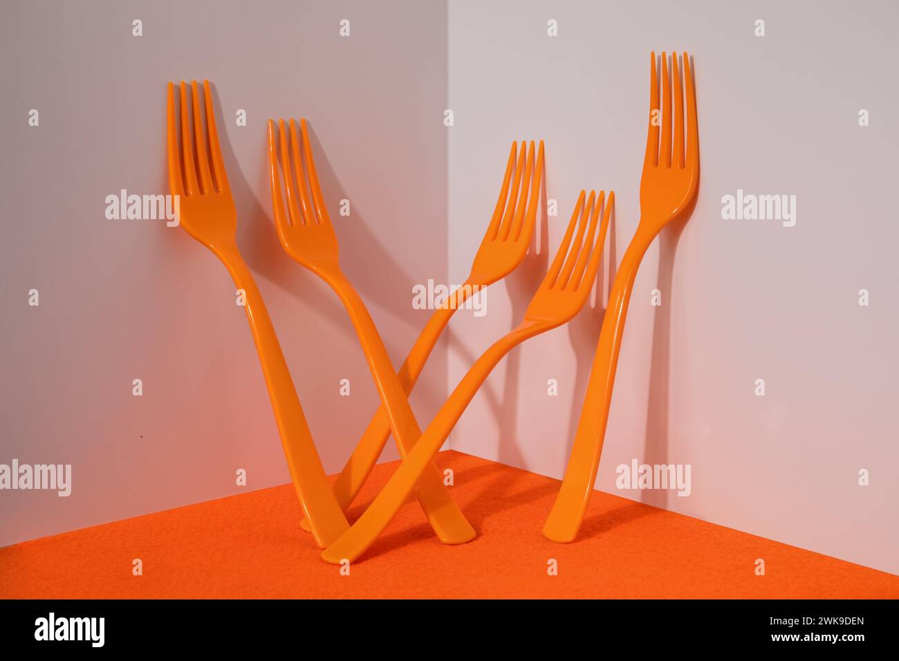 Five orange plastic forks on orange and white background Stock Photo ...