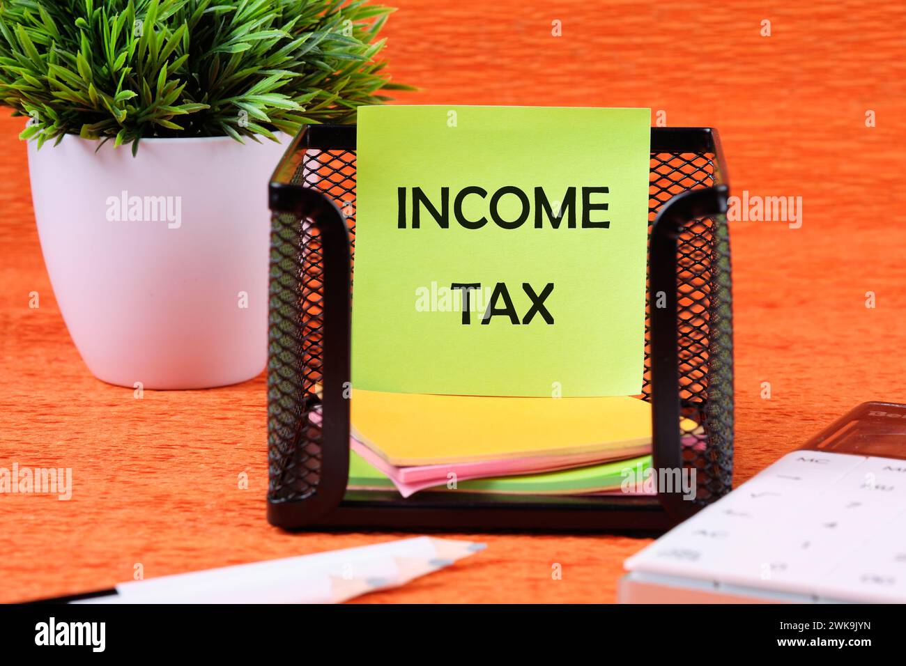 INCOME TAX text written on a green sticker next to office supplies on ...