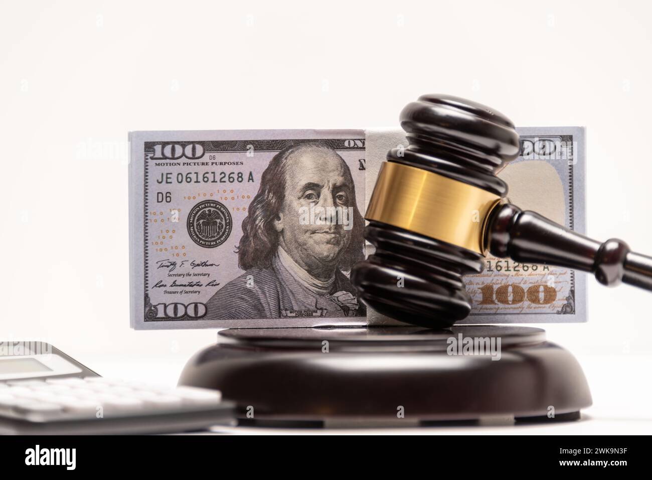 An isolated image of a judge's gavel on a stack of cash with a ...