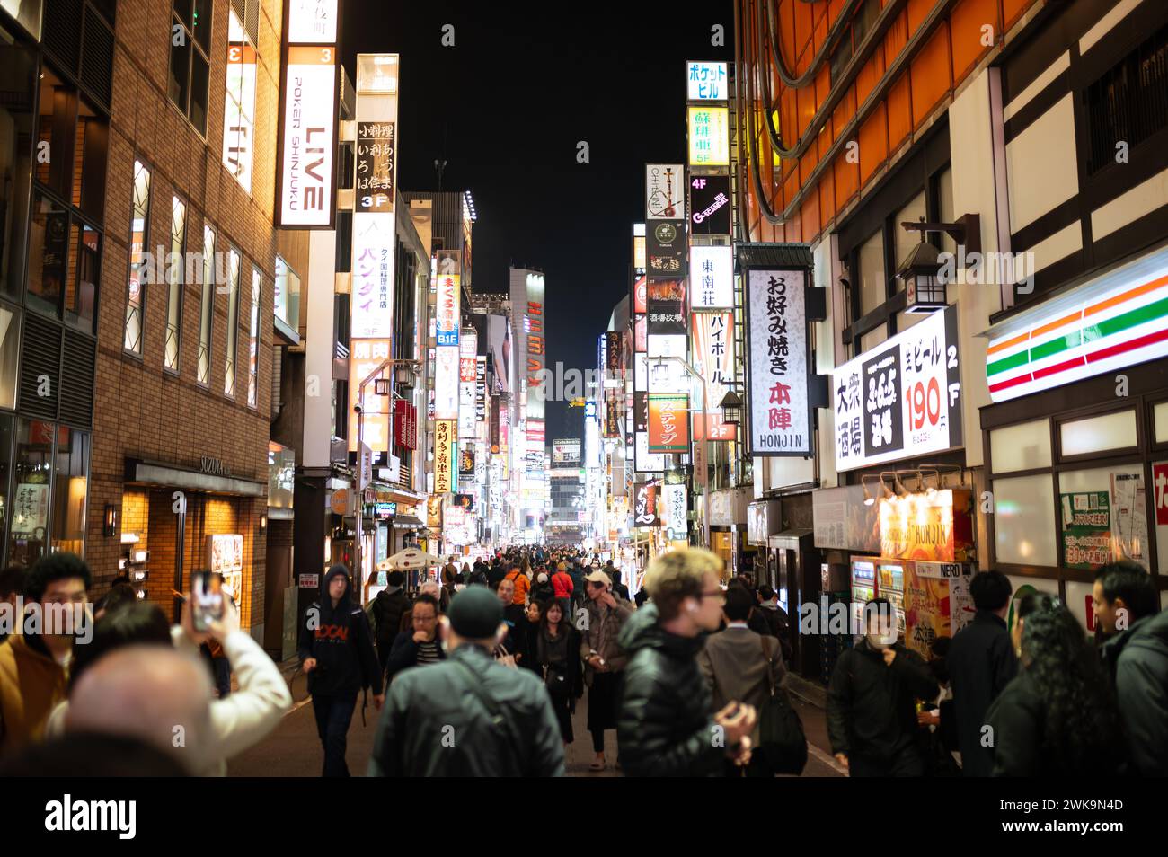 The busy evening life of Shinjuku with neon signs and active city ...