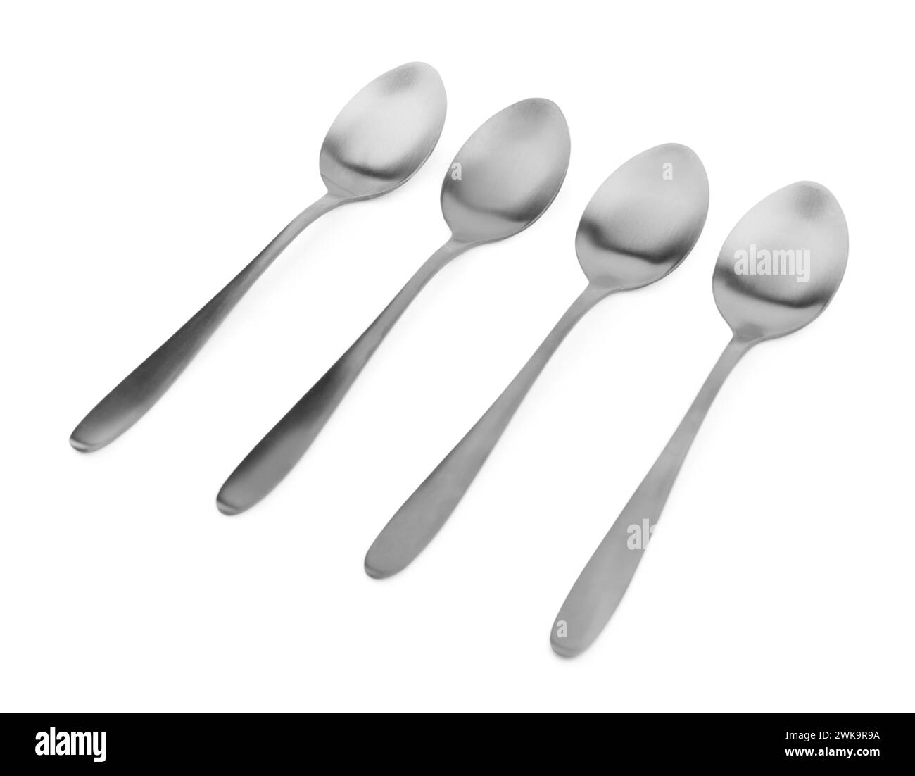 Stainless steel spoons on white background Stock Photo - Alamy