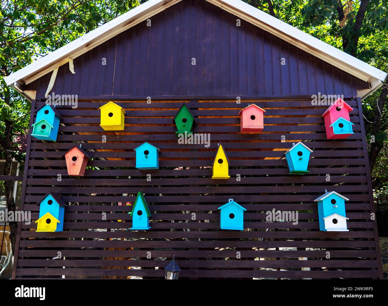 Colorful creative wooden nesting boxes birdhouse hanged on a wall in ...