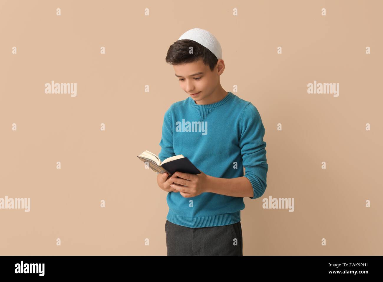 Little Muslim boy with Quran on beige background Stock Photo - Alamy