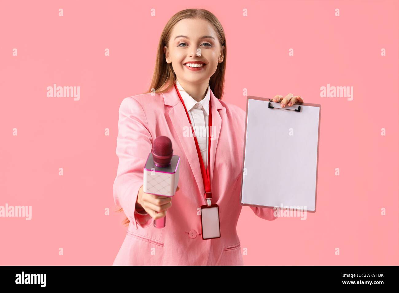 Female journalist with microphone and clipboard on pink background ...