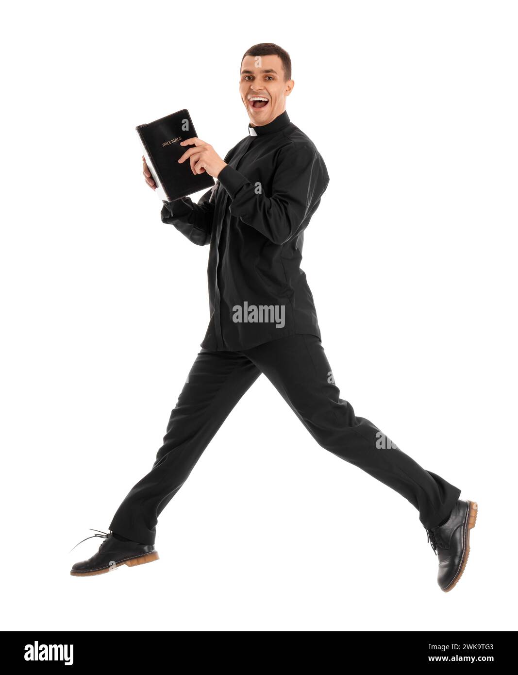 Young priest with Holy Bible jumping on white background Stock Photo ...