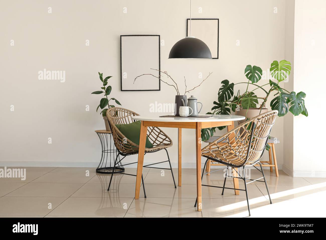 Interior of light room with dining table and frames Stock Photo - Alamy