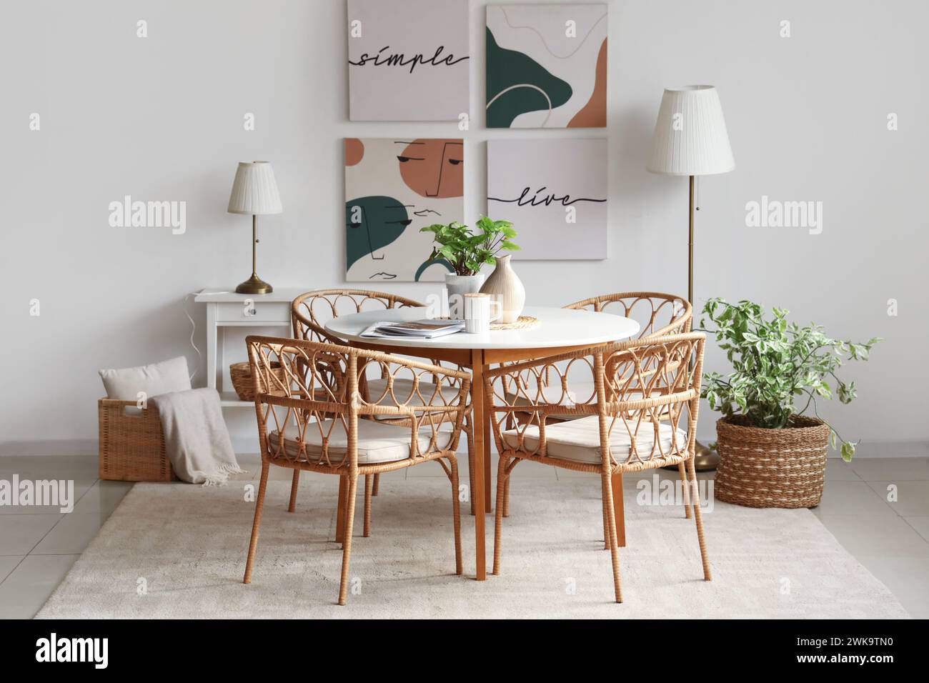 Interior of light room with dining table, paintings and lamps Stock ...