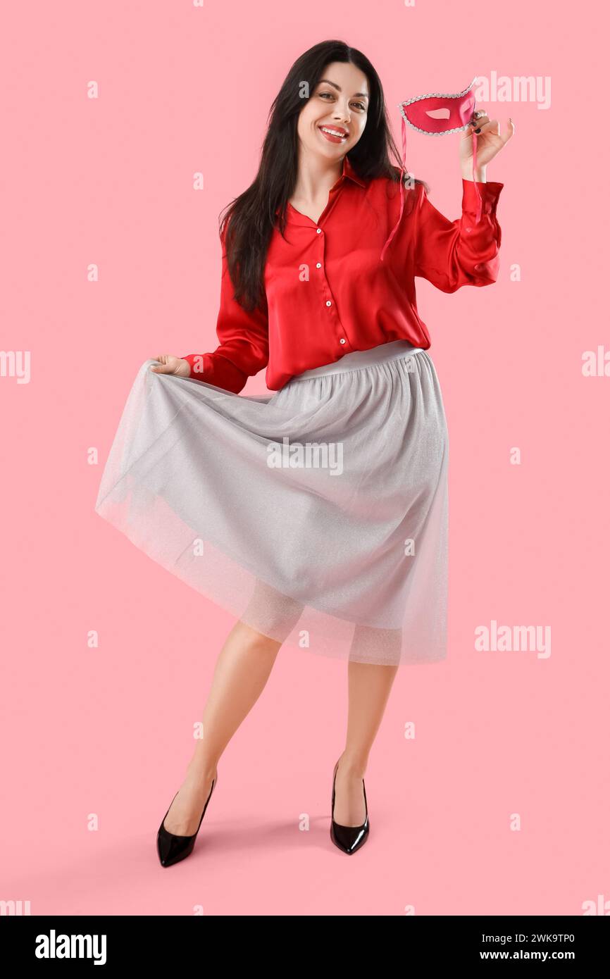 Happy young woman with carnival mask on pink background Stock Photo - Alamy