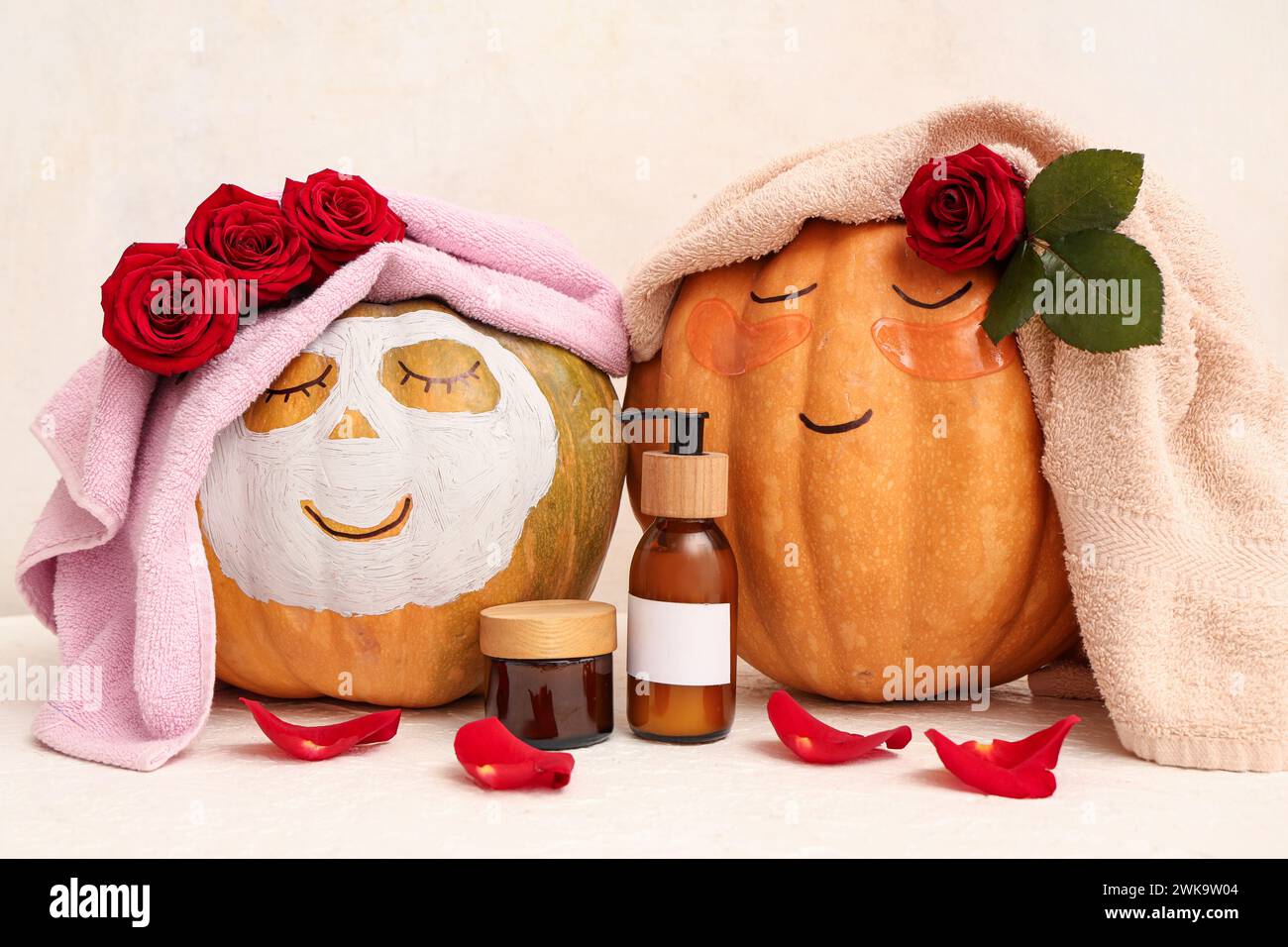 Pumpkin with drawn faces, spa supplies, roses and clay mask on light ...