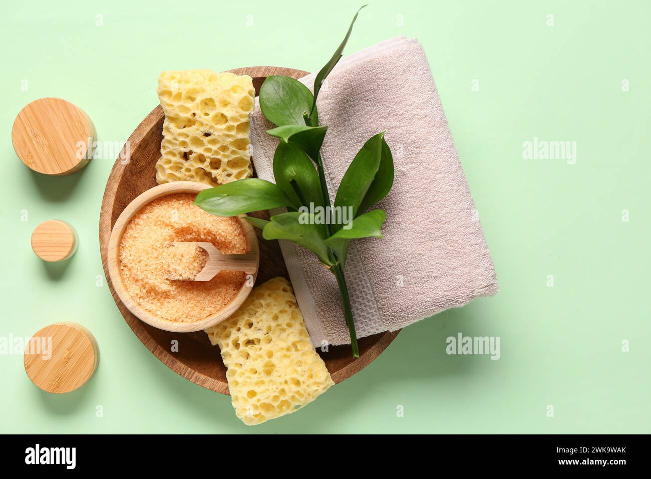 Wooden bowl with bath sponges, cotton towel, leaves and bowl with sea ...