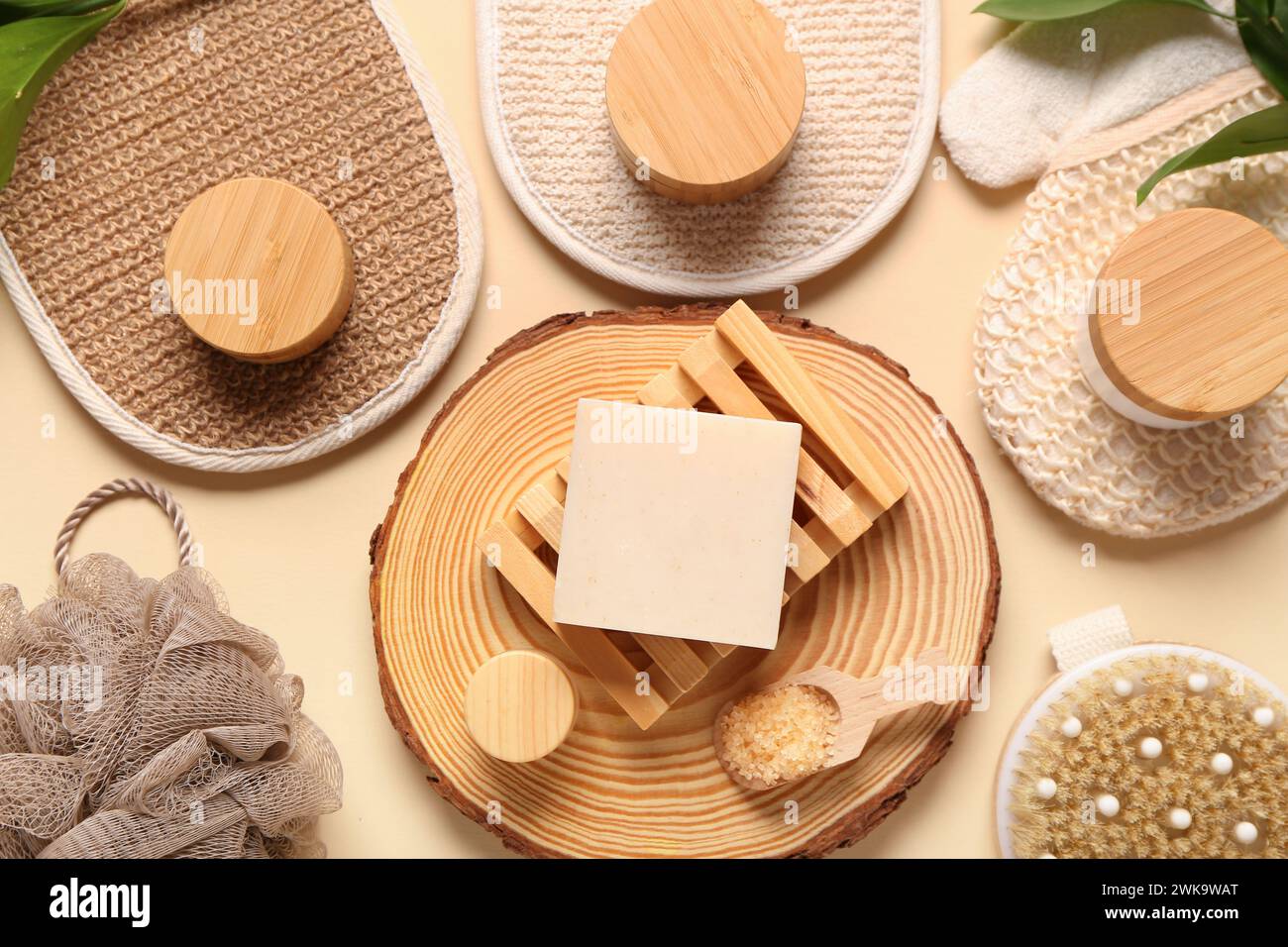 Wooden stand with soap bar, spoon with sea salt and jars of cream ...